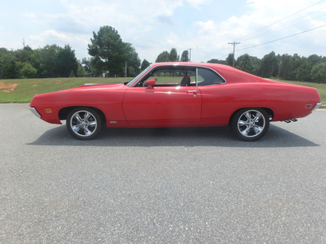 Restored and modified 70' Torino Sedan. Red exterior with black stripes.