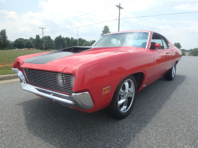 Restored and modified 70' Torino Sedan. Red exterior with black stripes.