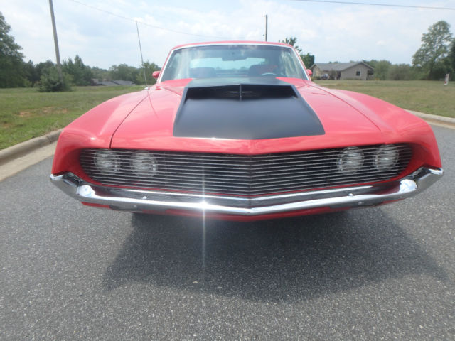 Restored and modified 70' Torino Sedan. Red exterior with black stripes.