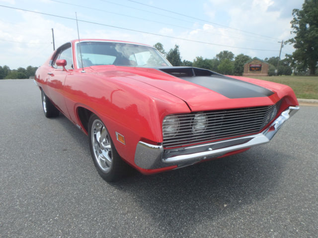 Restored and modified 70' Torino Sedan. Red exterior with black stripes.